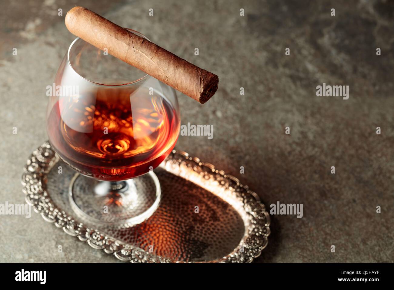 Snifter of brandy and cigar on an old stone table. Copy space Stock ...