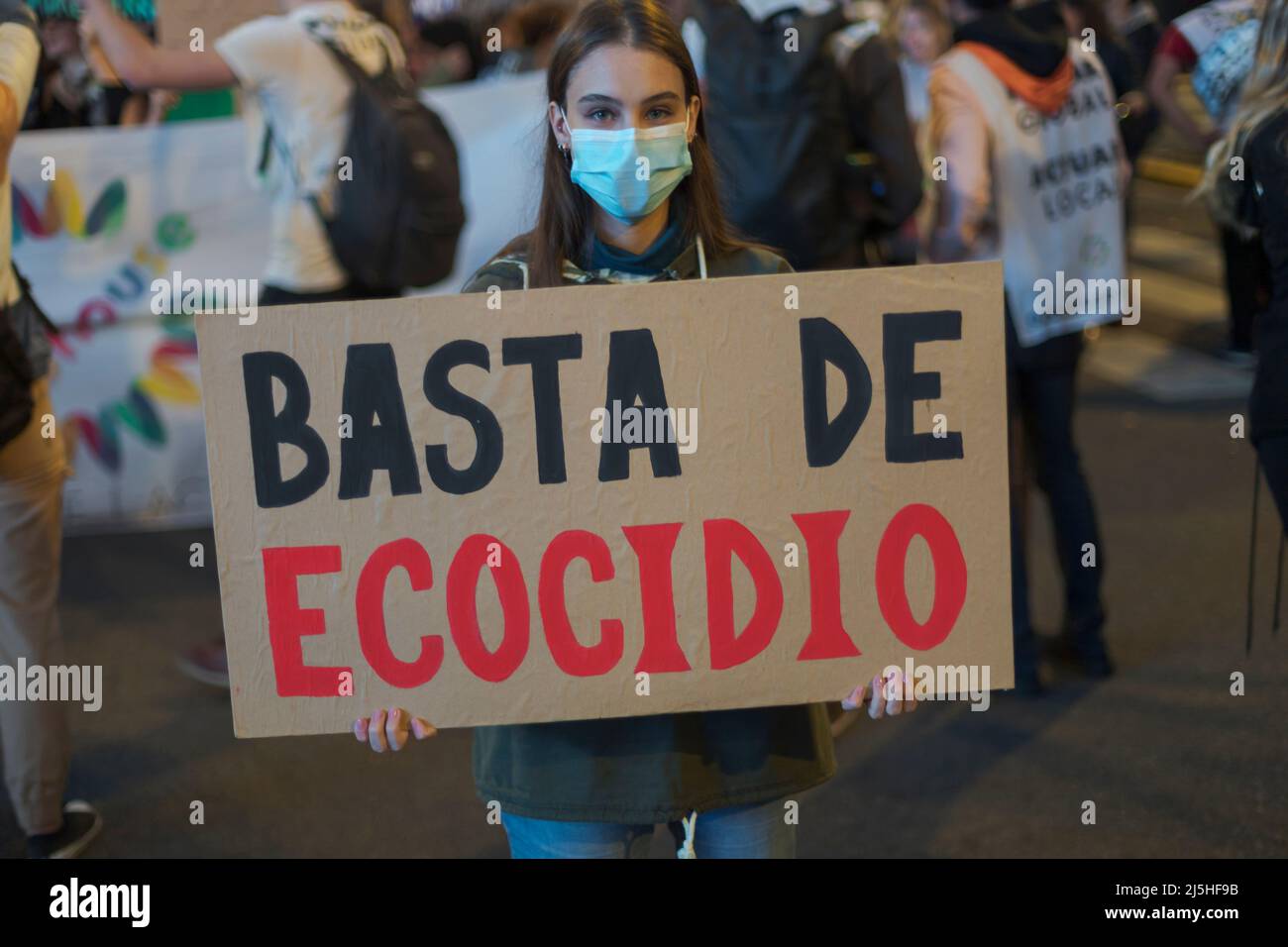 A protester holds a sign that says Stop Ecocide during the Earth Day ...