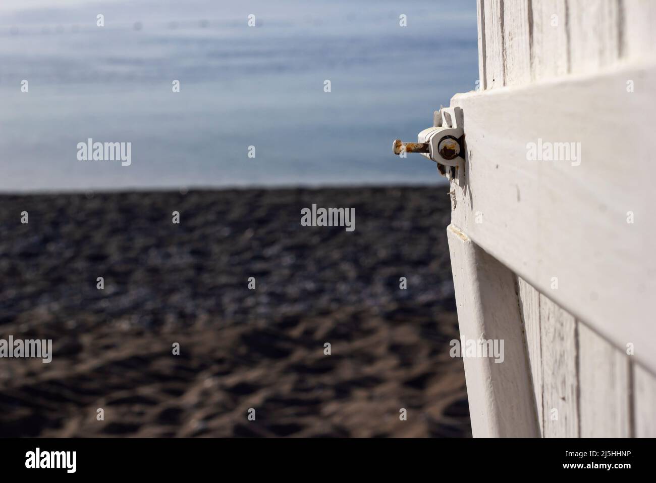 Close-up of locker cabin door on the beach. Lock and clothes hanger ...