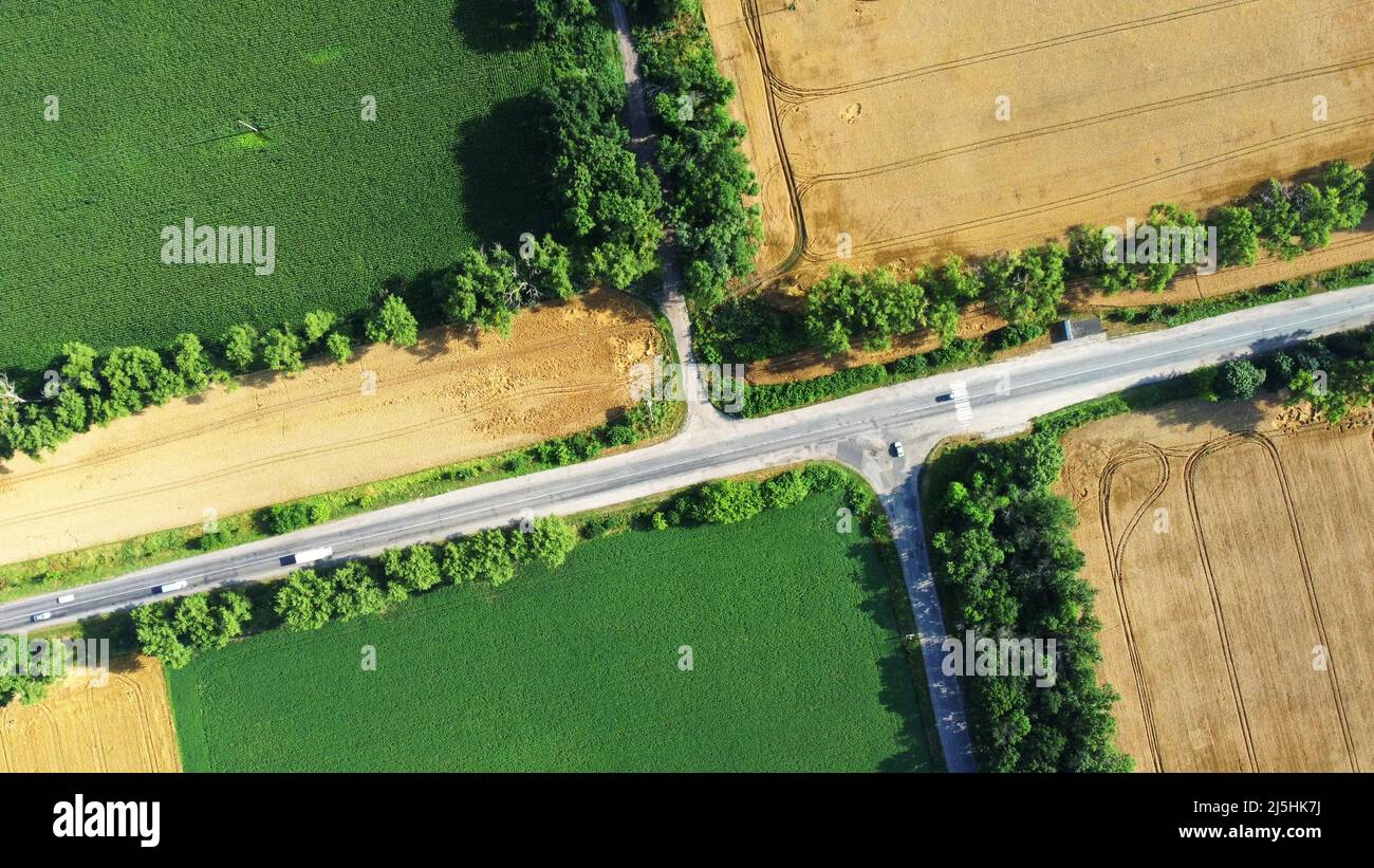 Aerial drone view over asphalt road intersection between agricultural ...