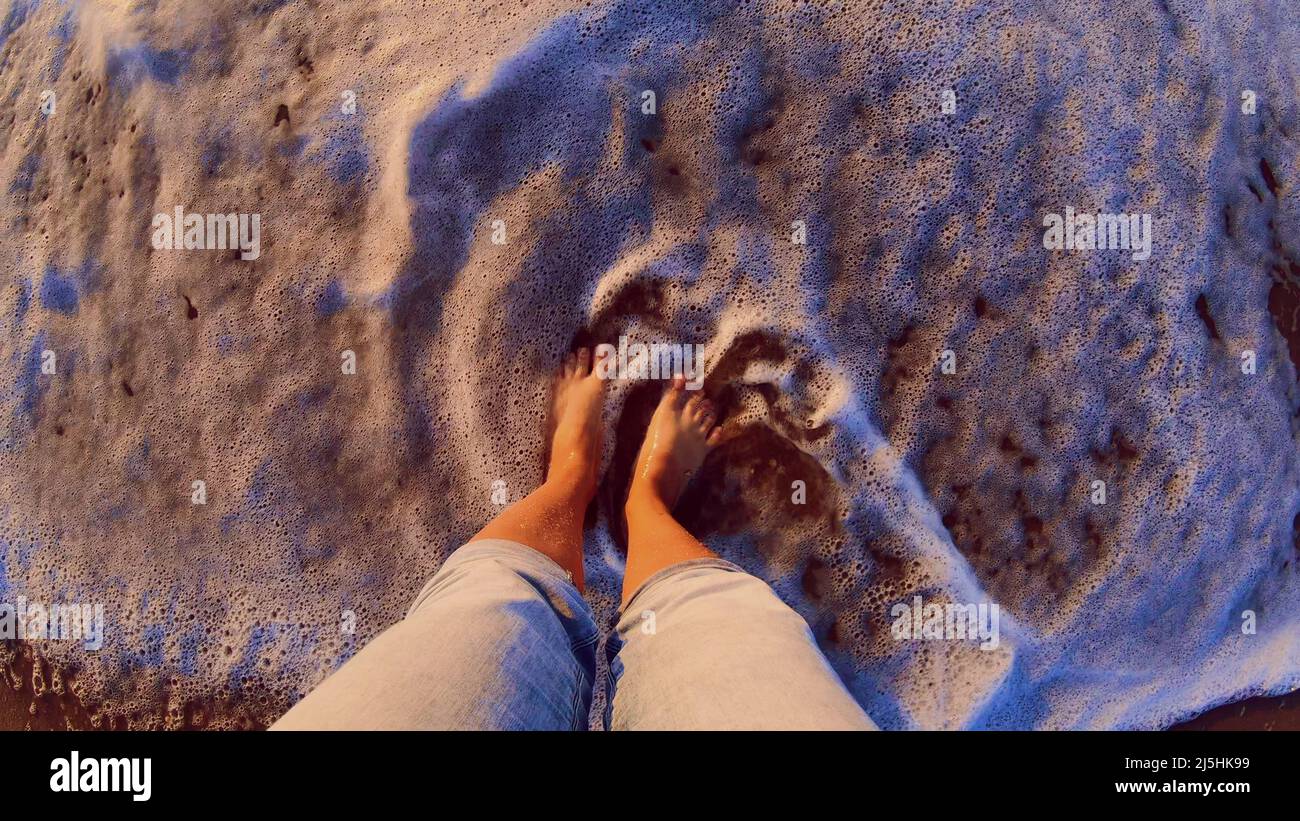 Girl standing on sandy beach. Sea ocean wave with white foam rolls ...