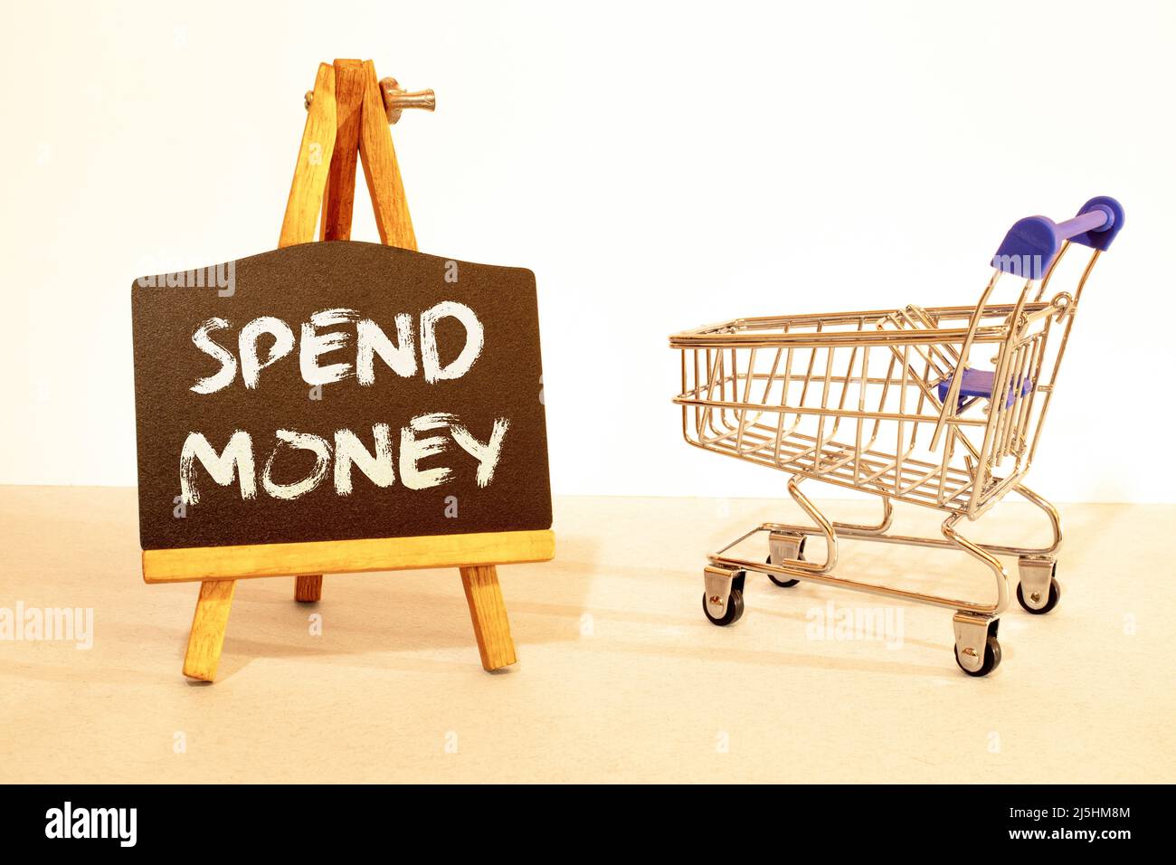 SPEND MONEY lettering on black board, grocery trolley Stock Photo - Alamy