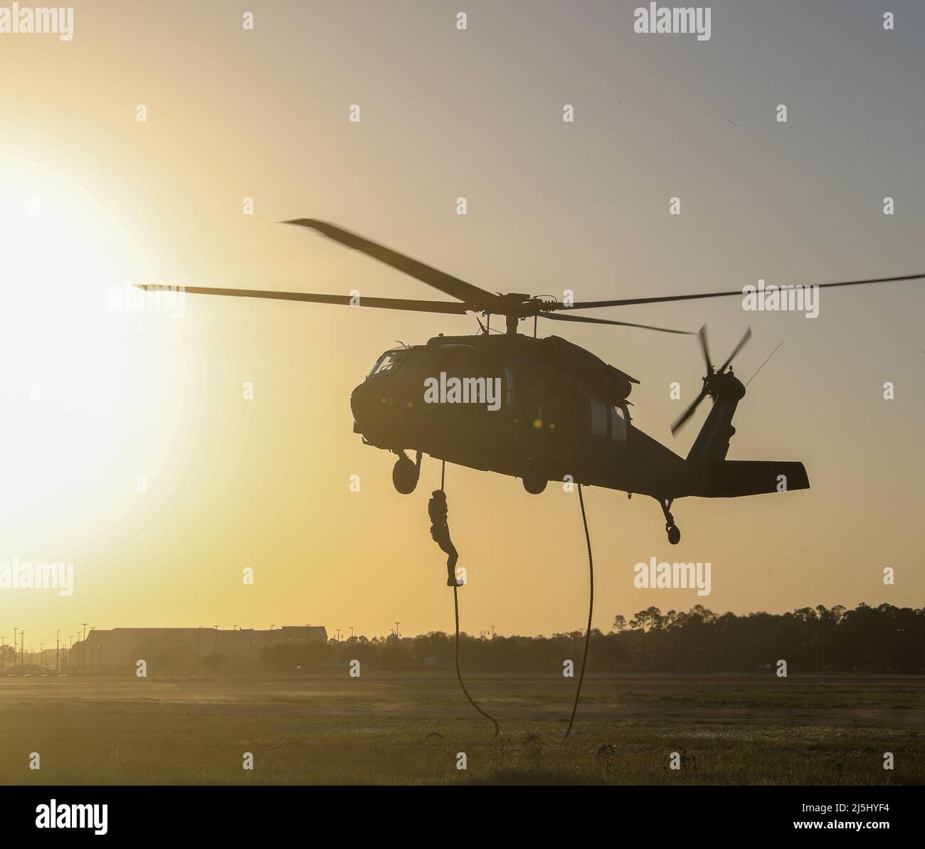 A U.S. special operations service member descends from UH-60 Black Hawk ...