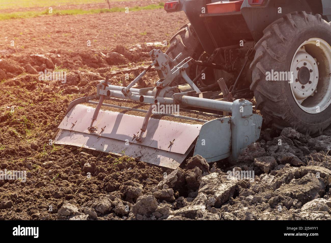 Milling mashine loosens and cultivates soil on field. Prepare for ...