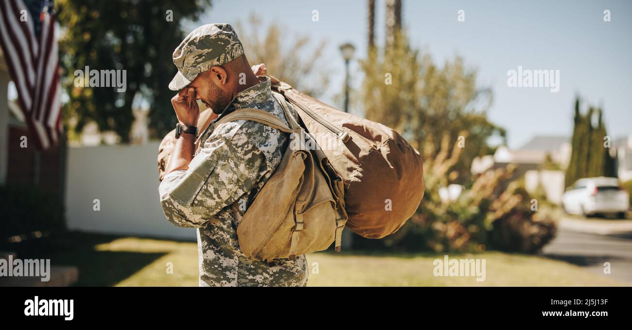 American soldier walking towards his house with his luggage. Emotional ...