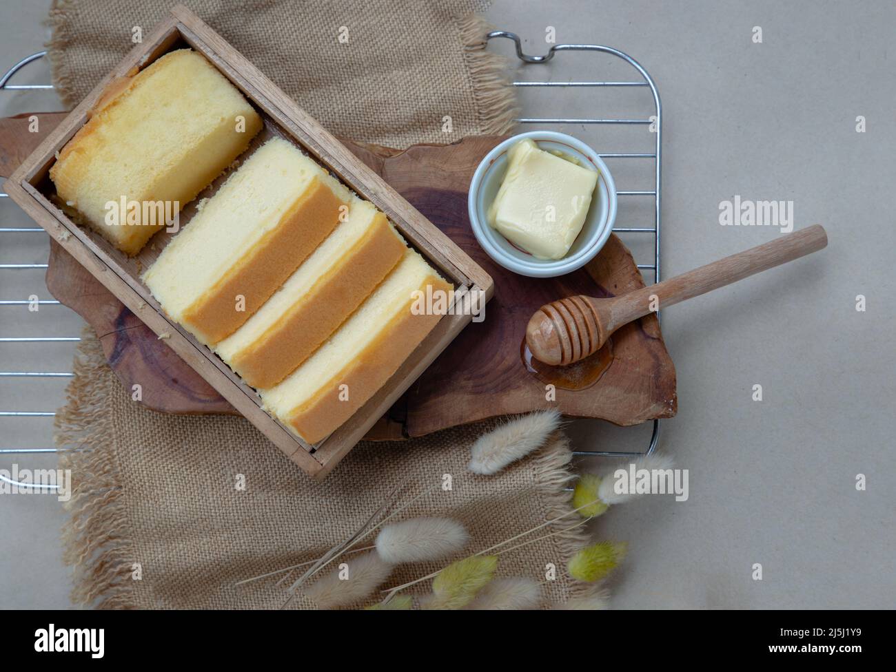 Slices of four butter cakes in wooden box served with butter and honey ...