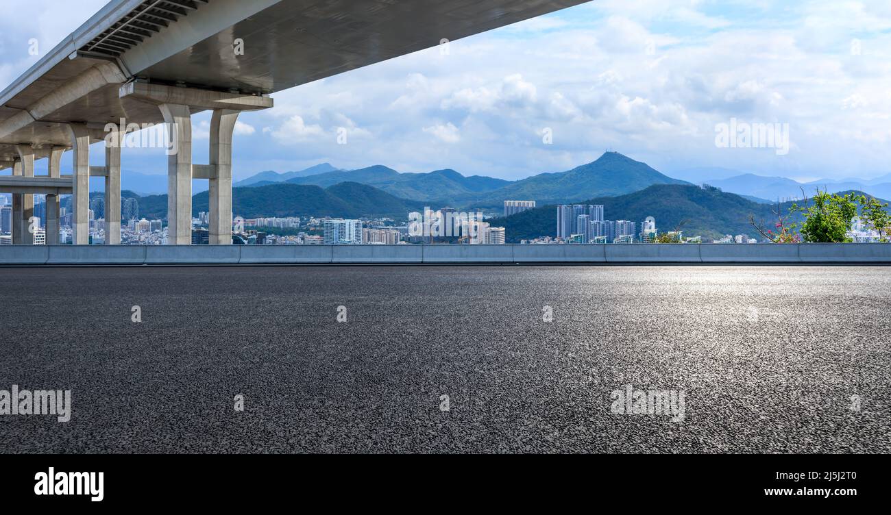 Asphalt road and city skyline with bridge scenery in Hainan, China ...