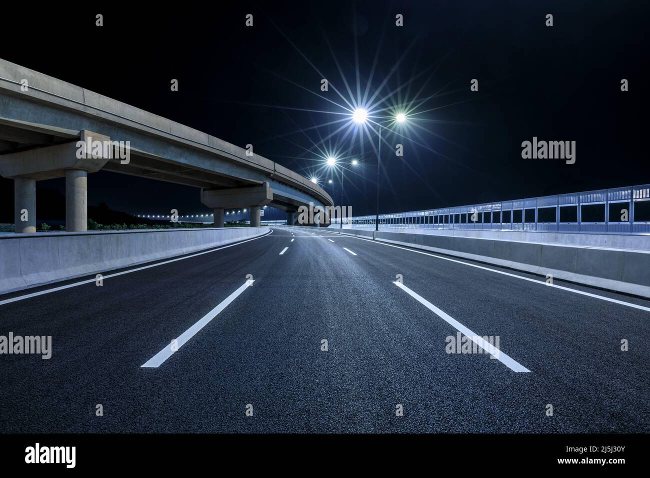 Empty asphalt road and bridge building at night Stock Photo - Alamy