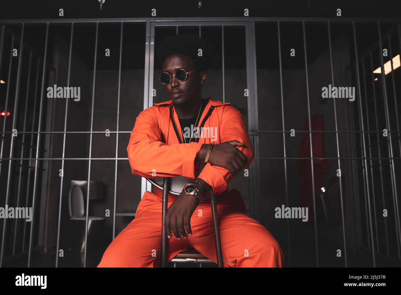 Black prisoner in an orange jumpsuit posing in front of his cell Stock ...
