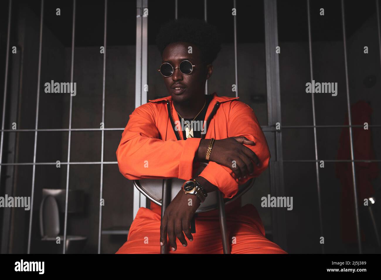 Black prisoner in an orange jumpsuit posing in front of his cell Stock ...