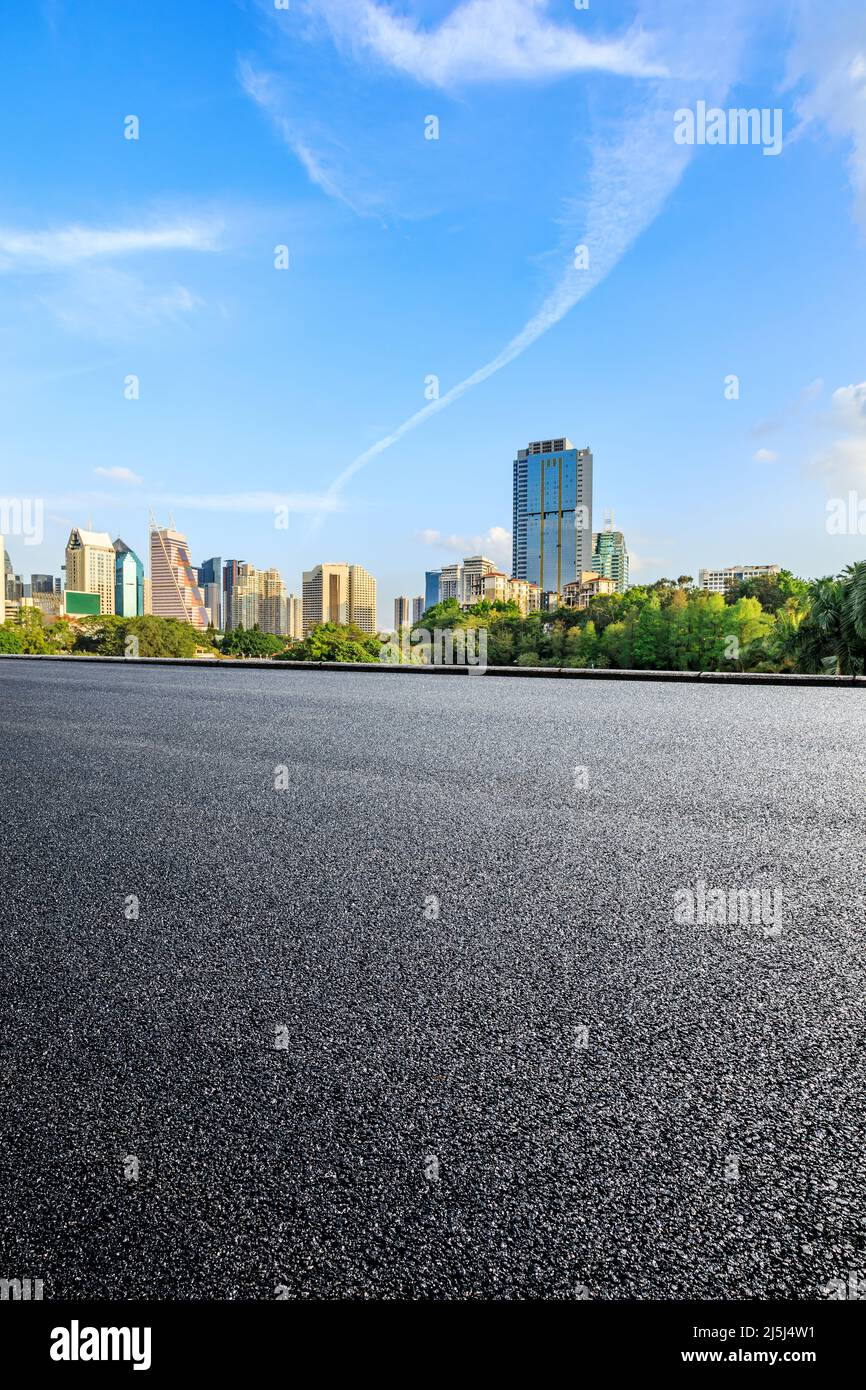 Asphalt road platform and city skyline with modern commercial buildings ...