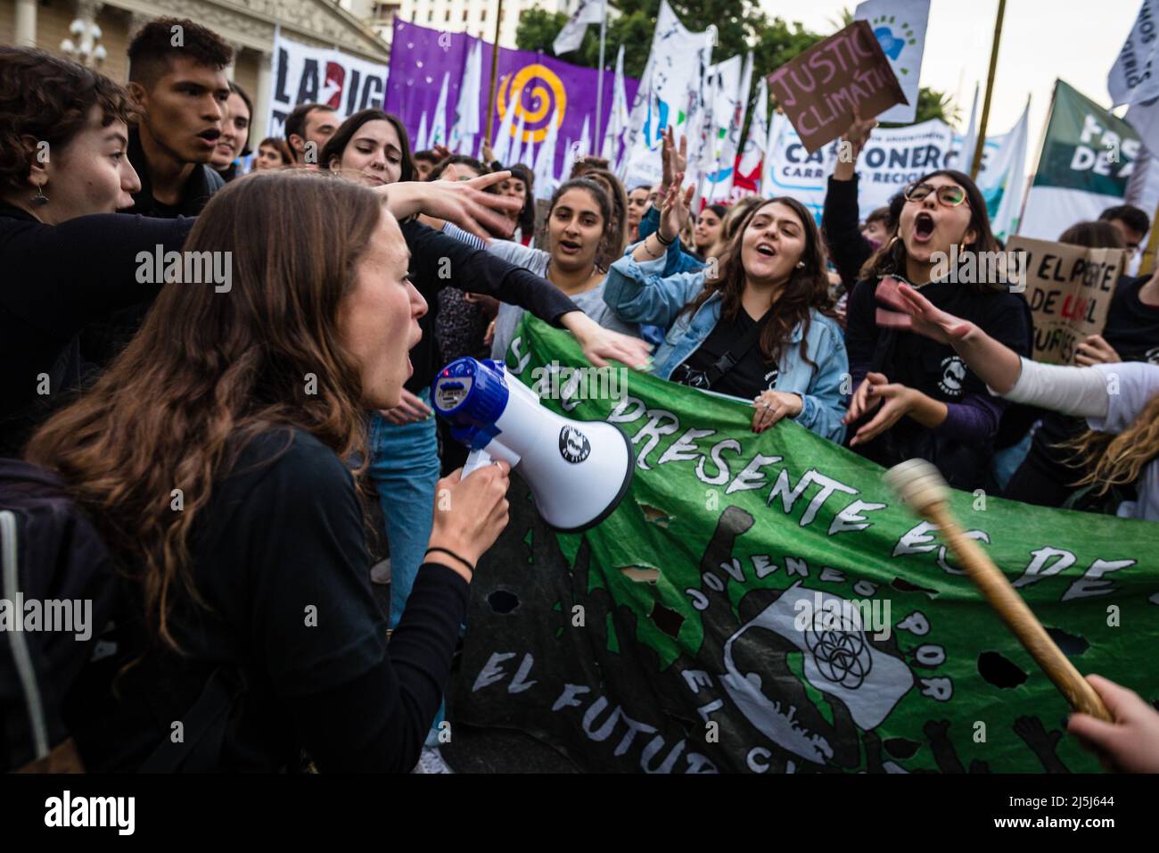 A young woman with a megaphone shouts slogans against climate change ...