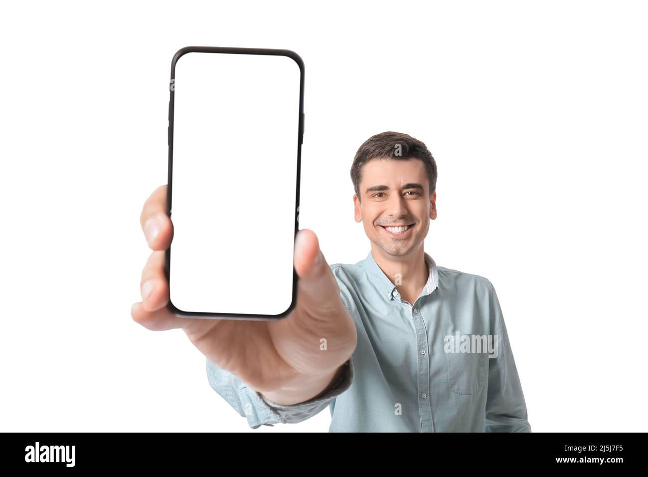 Young man showing mobile phone with blank screen on white background ...