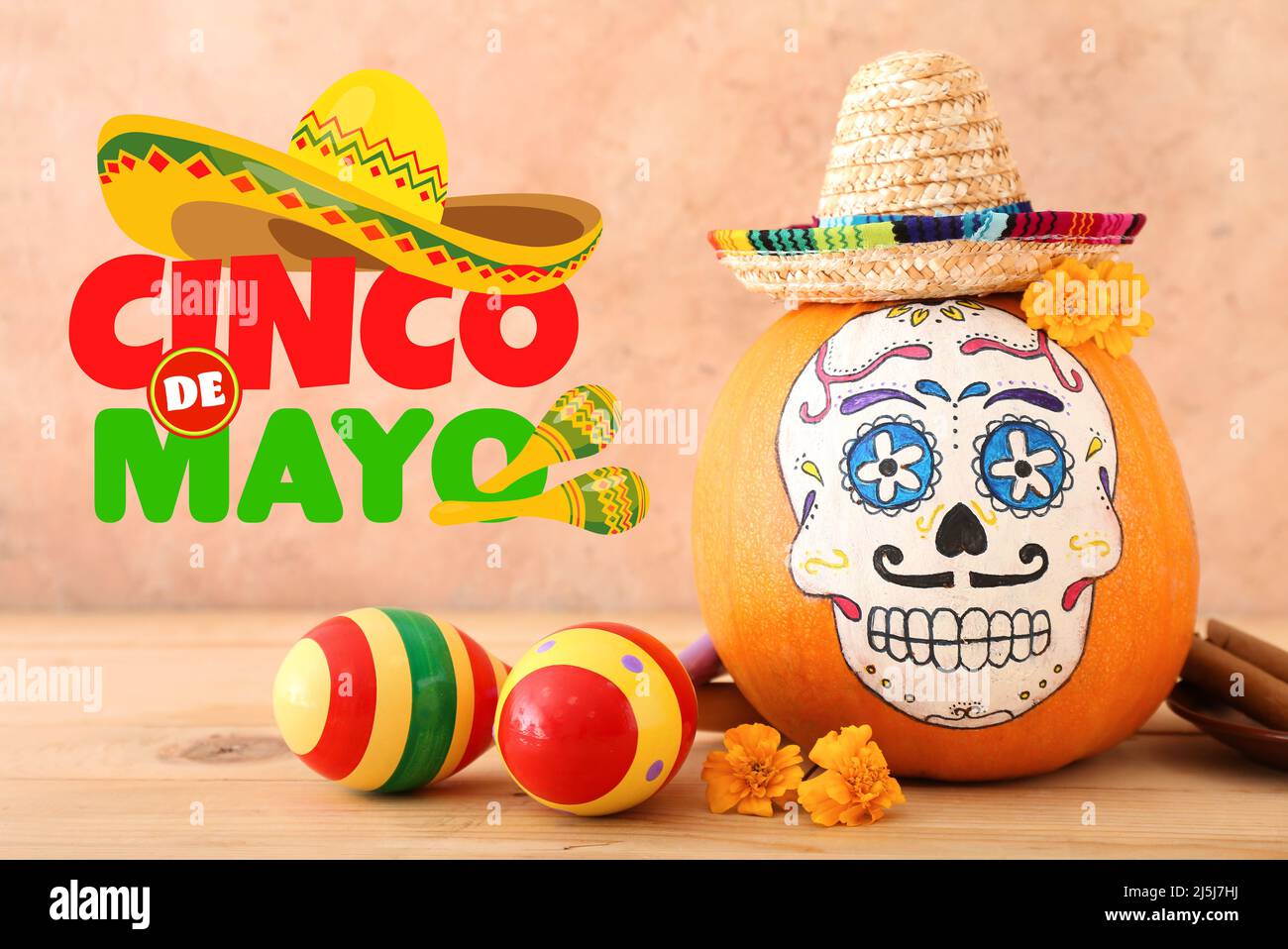 Pumpkin with painted skull, sombrero and maracas on color background ...