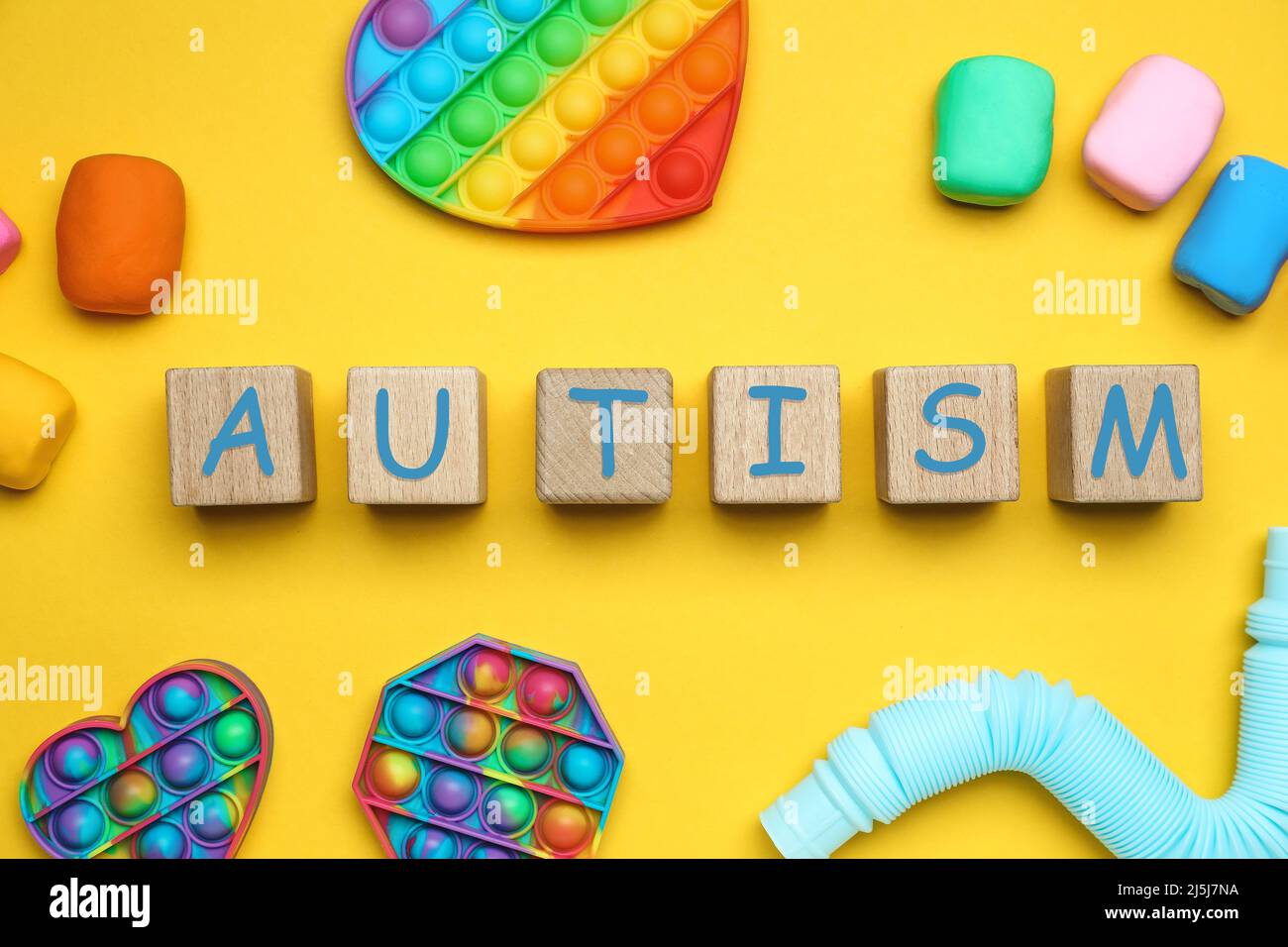 Word AUTISM made of cubes and toys on yellow background Stock Photo - Alamy