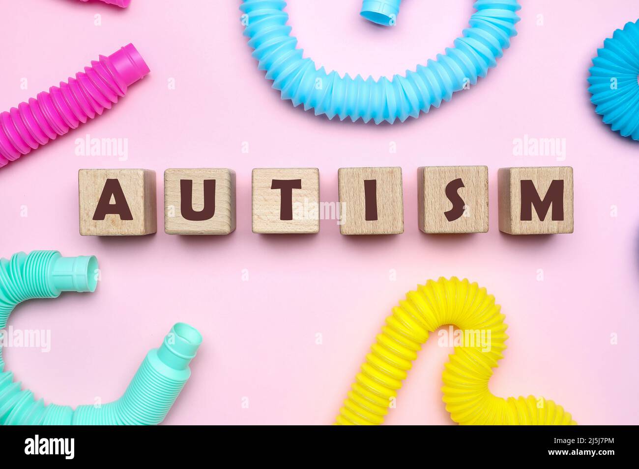 Word AUTISM made of cubes and pop tubes on pink background Stock Photo ...