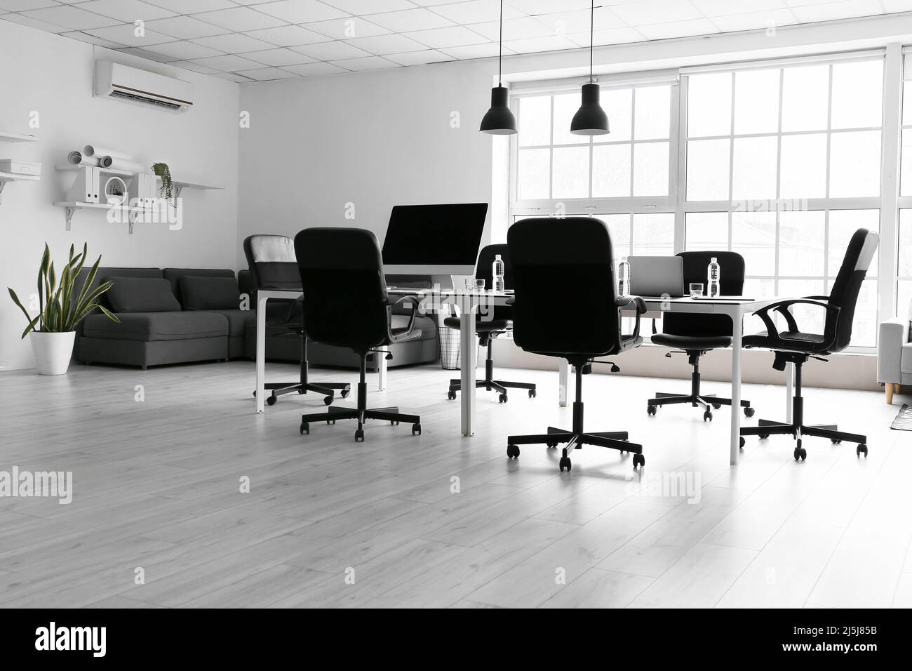 Interior of light office with table, chairs and sofa Stock Photo - Alamy