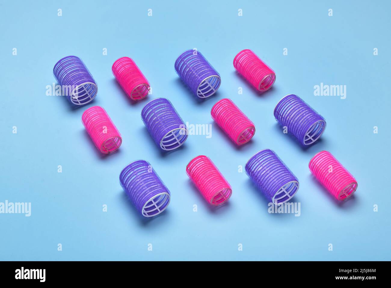 Set of different hair curlers on blue background Stock Photo - Alamy