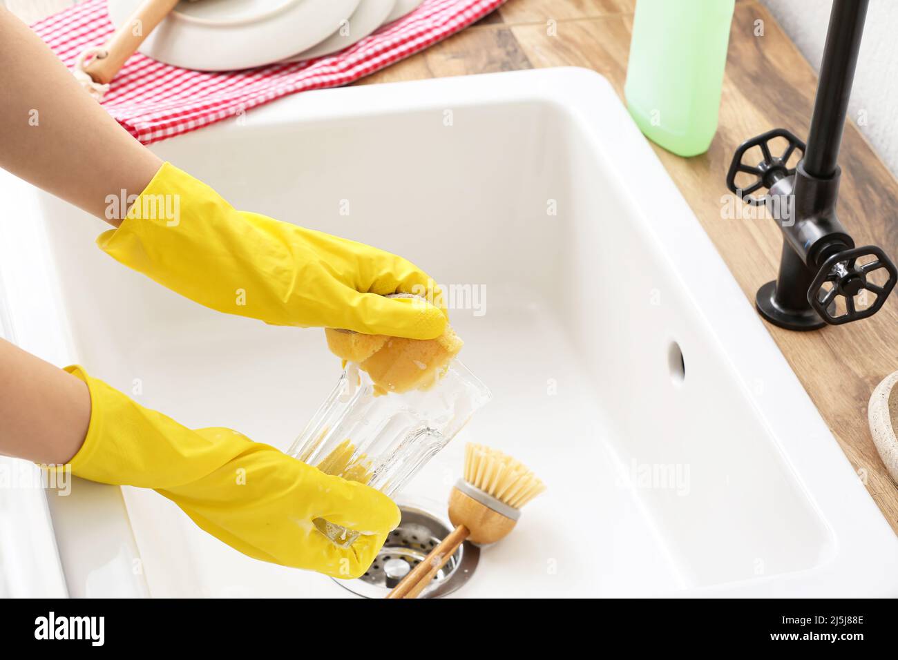 Woman in rubber gloves washing glass in sink, closeup Stock Photo - Alamy