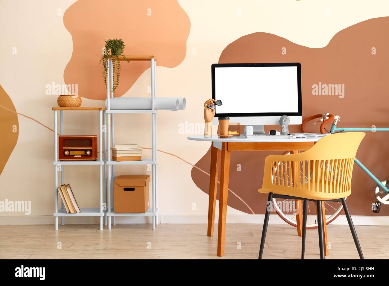 Shelf unit and comfortable workplace near color wall in room interior ...