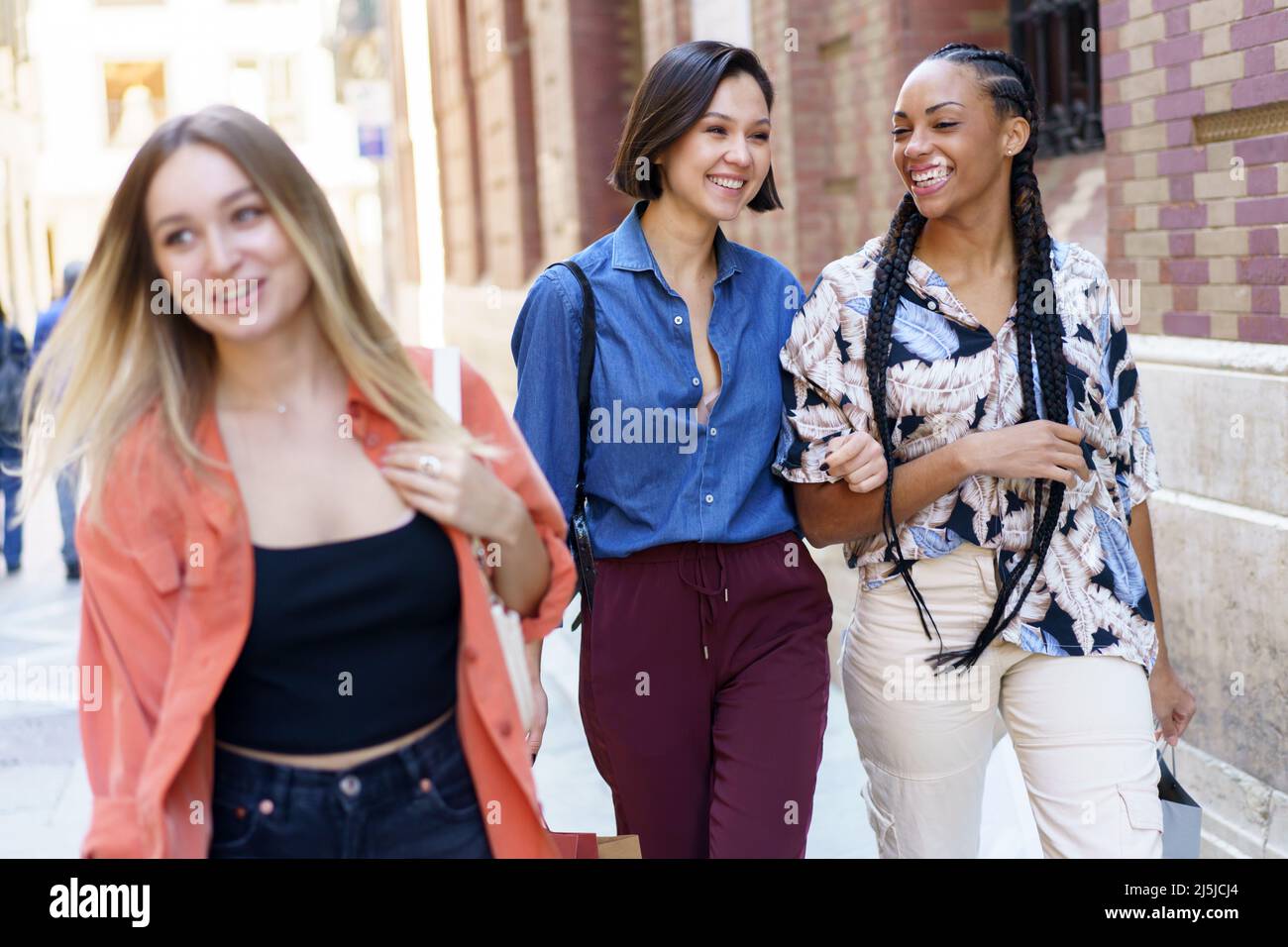 Content multiracial women walking on street during shopping Stock Photo ...