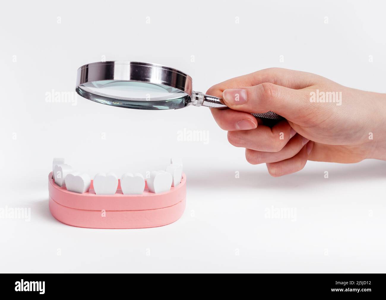 Tooth checkup concept. Hand with magnifying glass conducting oral exam ...