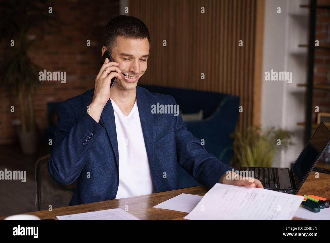 Handsome caucasian manager sitting at office desk in front laptop hold ...