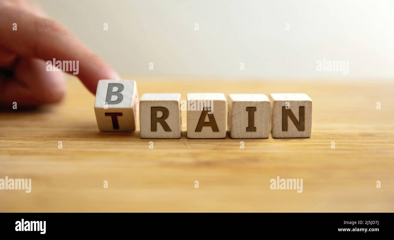 Train your brain concept. Hand flips letter on wooden cube changing the ...