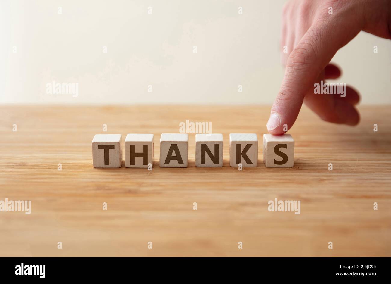 Thanks concept. Word thanks on wooden cube with finger to shows letter ...