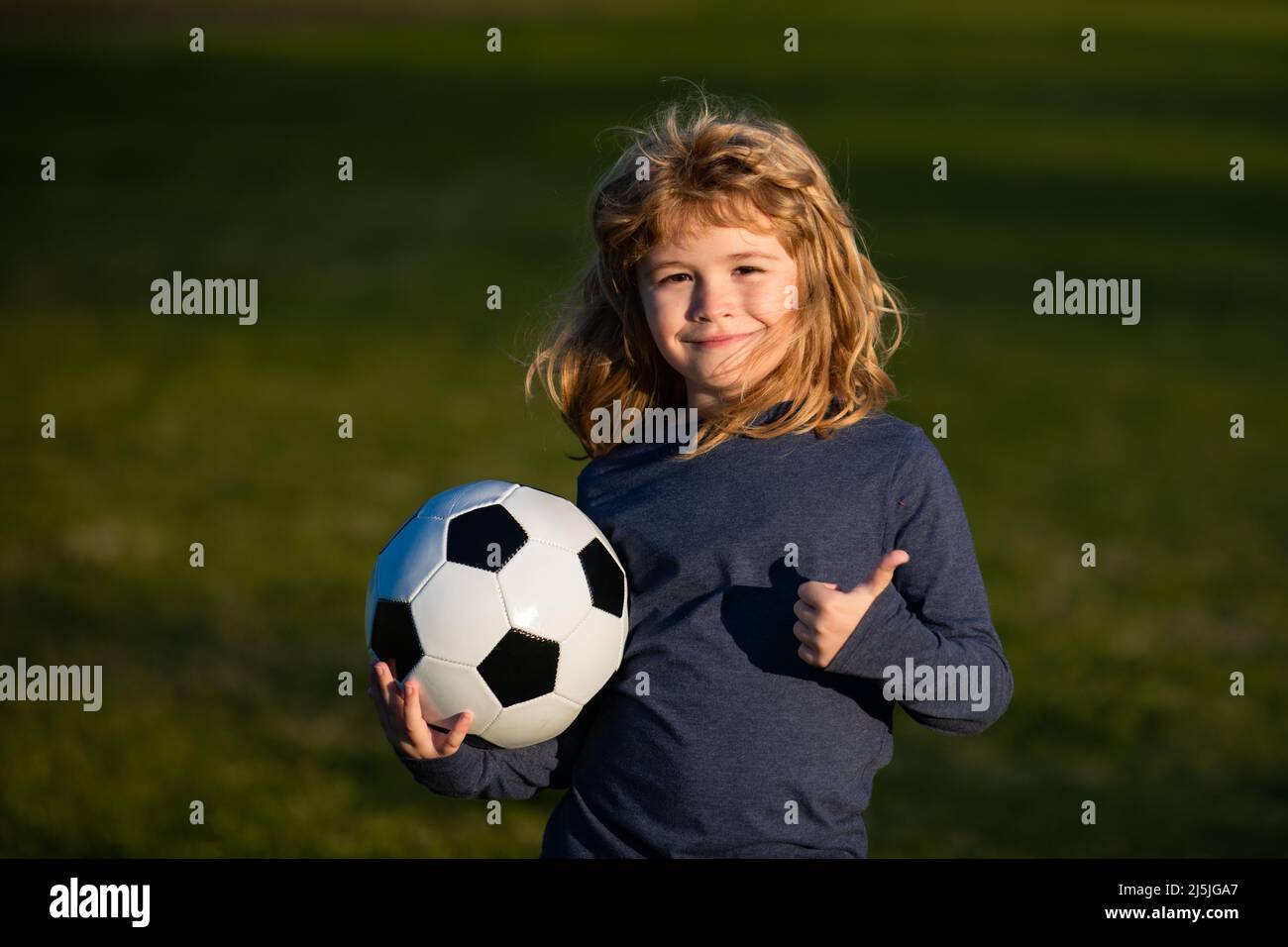 Boy child playing football on football field. Kid playing soccer show ...