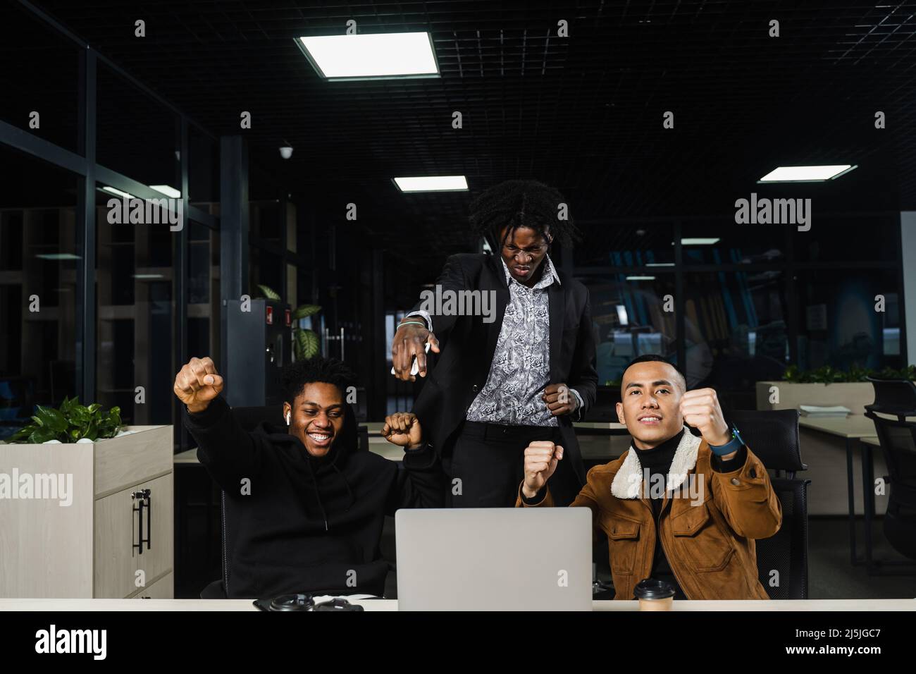 Emotional and joyful black Africans and Asians teamwork together and ...