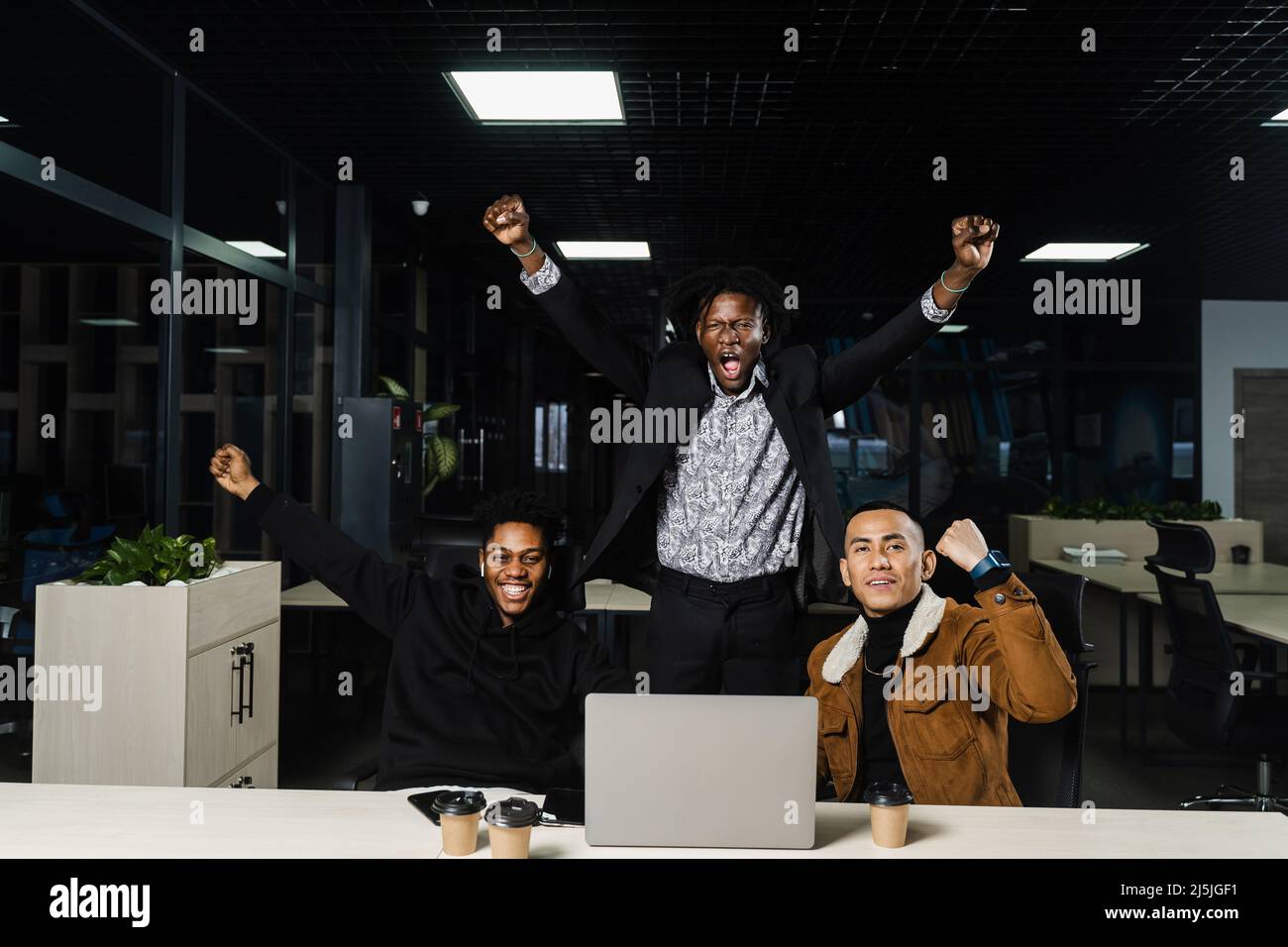 Teambuilding black Africans and Asians. Positive mixed race colleagues ...