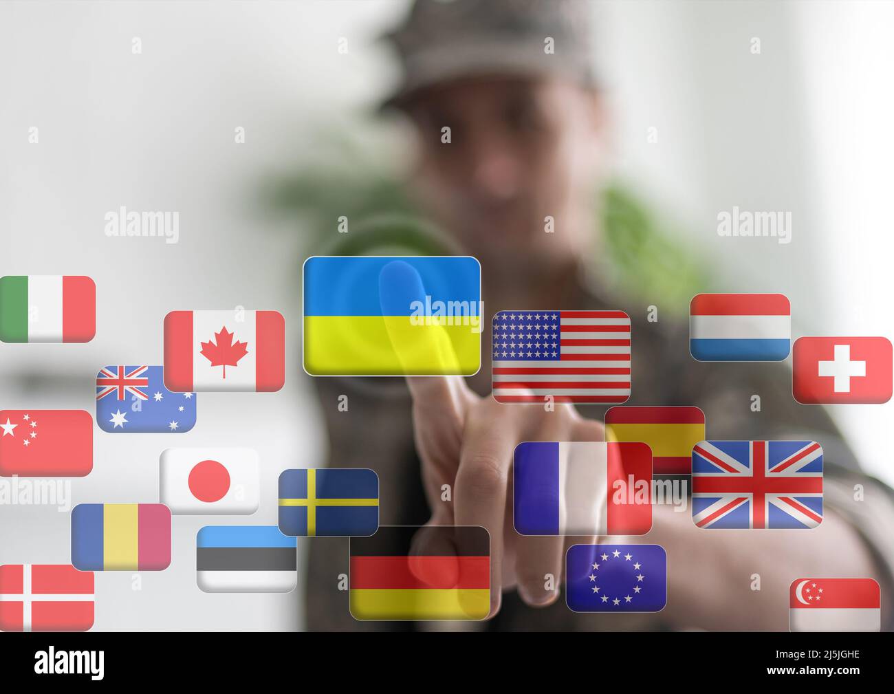 Hand pushing on a touch screen interface, choosing Ukraine. flags of ...