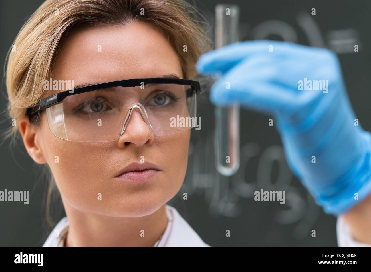 Scientist inspecting substance inside the test tube in a laboratory ...