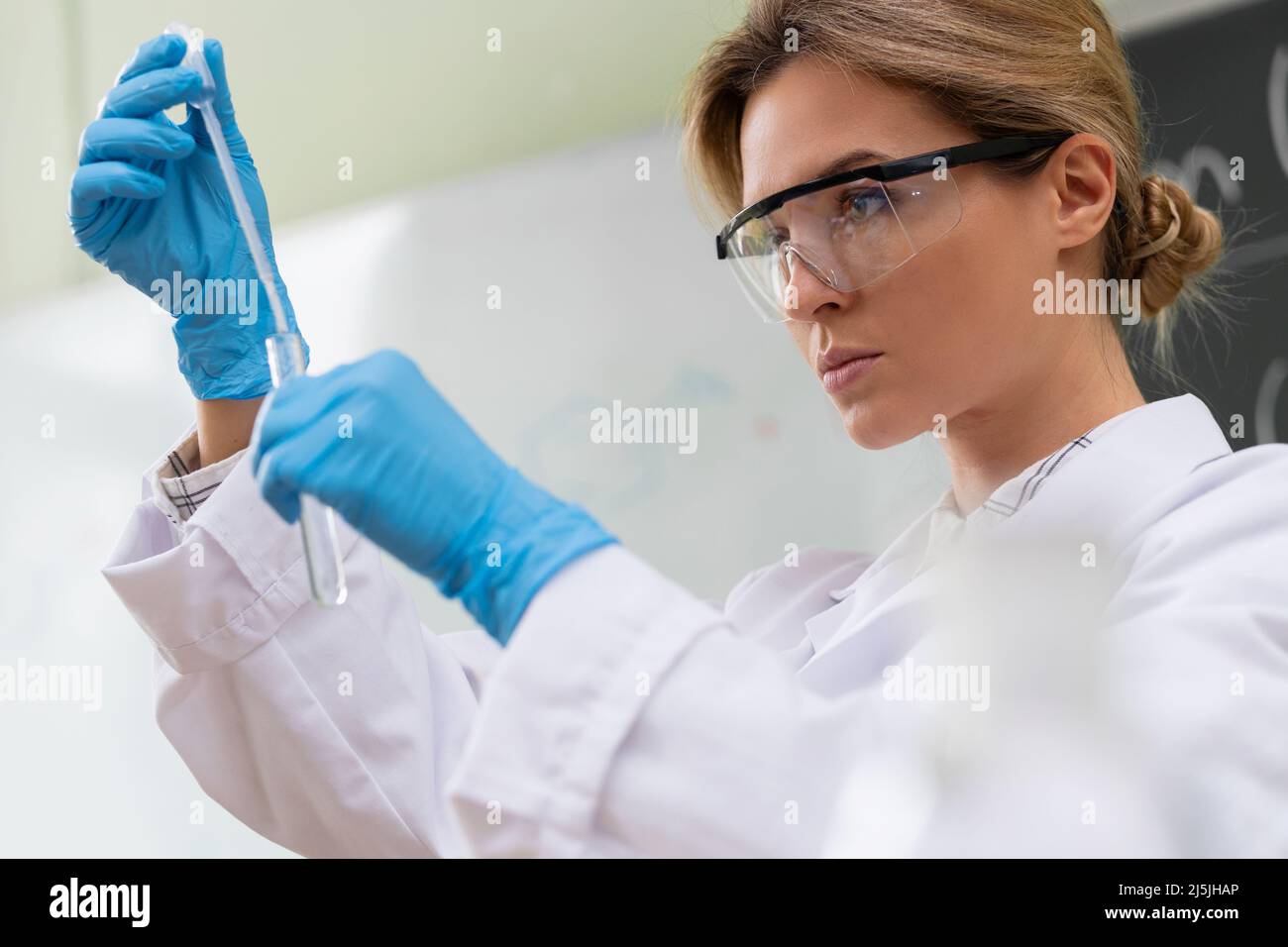 Scientist is using dropper and test tube in a laboratory during ...