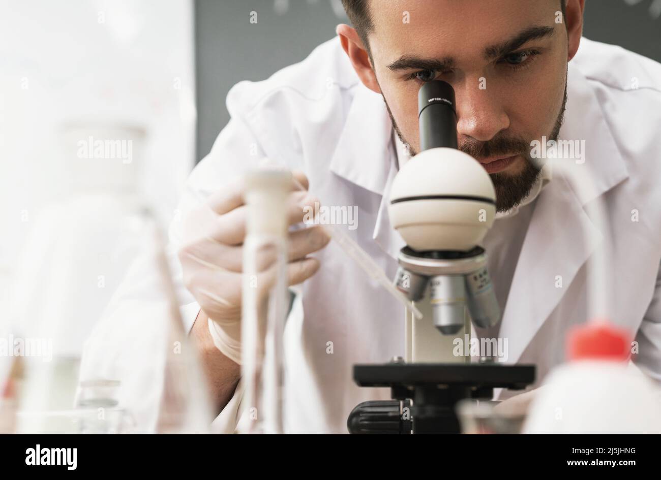 Scientist is using microscope in a laboratory during research work ...