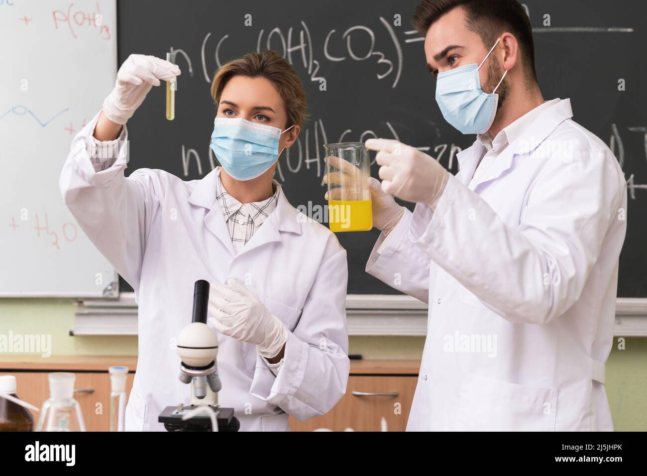 Two scientist colleagues is working with a chemical reagents in a ...