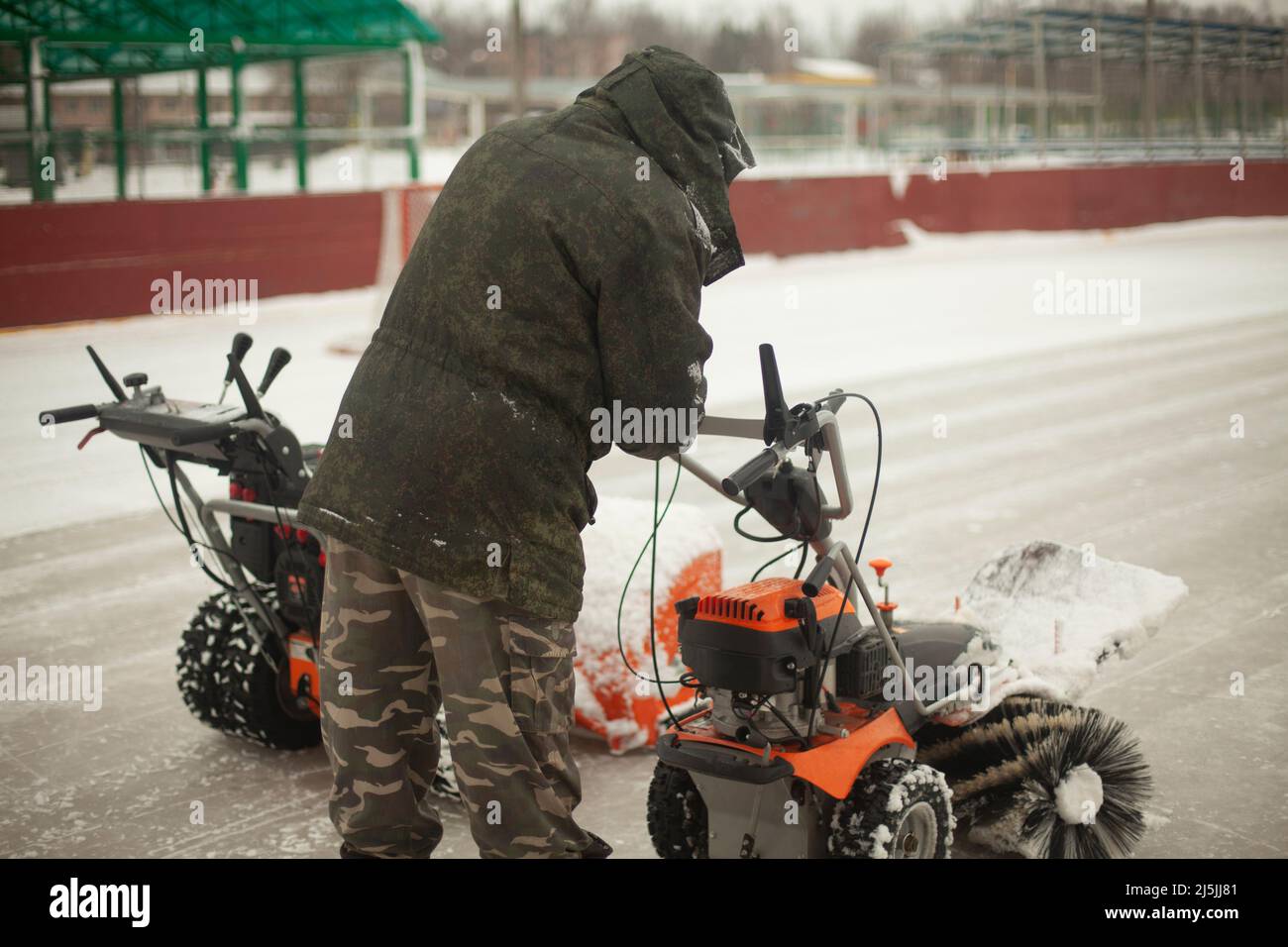 The worker prepares snow ploughing equipment for work. A man checks the ...