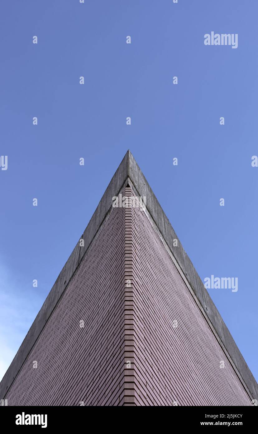 detail of the corner of a brick building with a concrete roof with blue ...