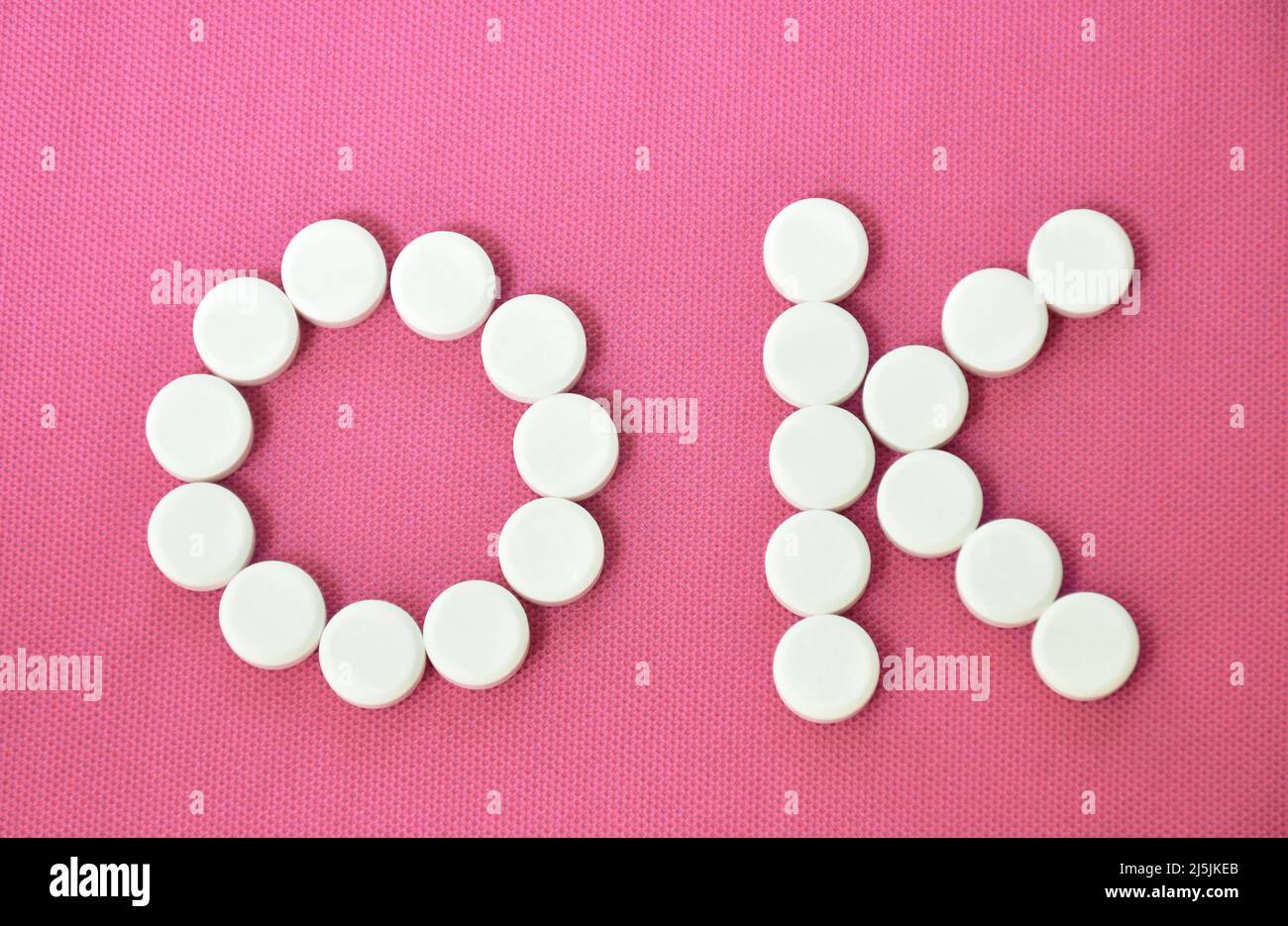 white tablet medicine arranging OK symbol on pink background Stock ...