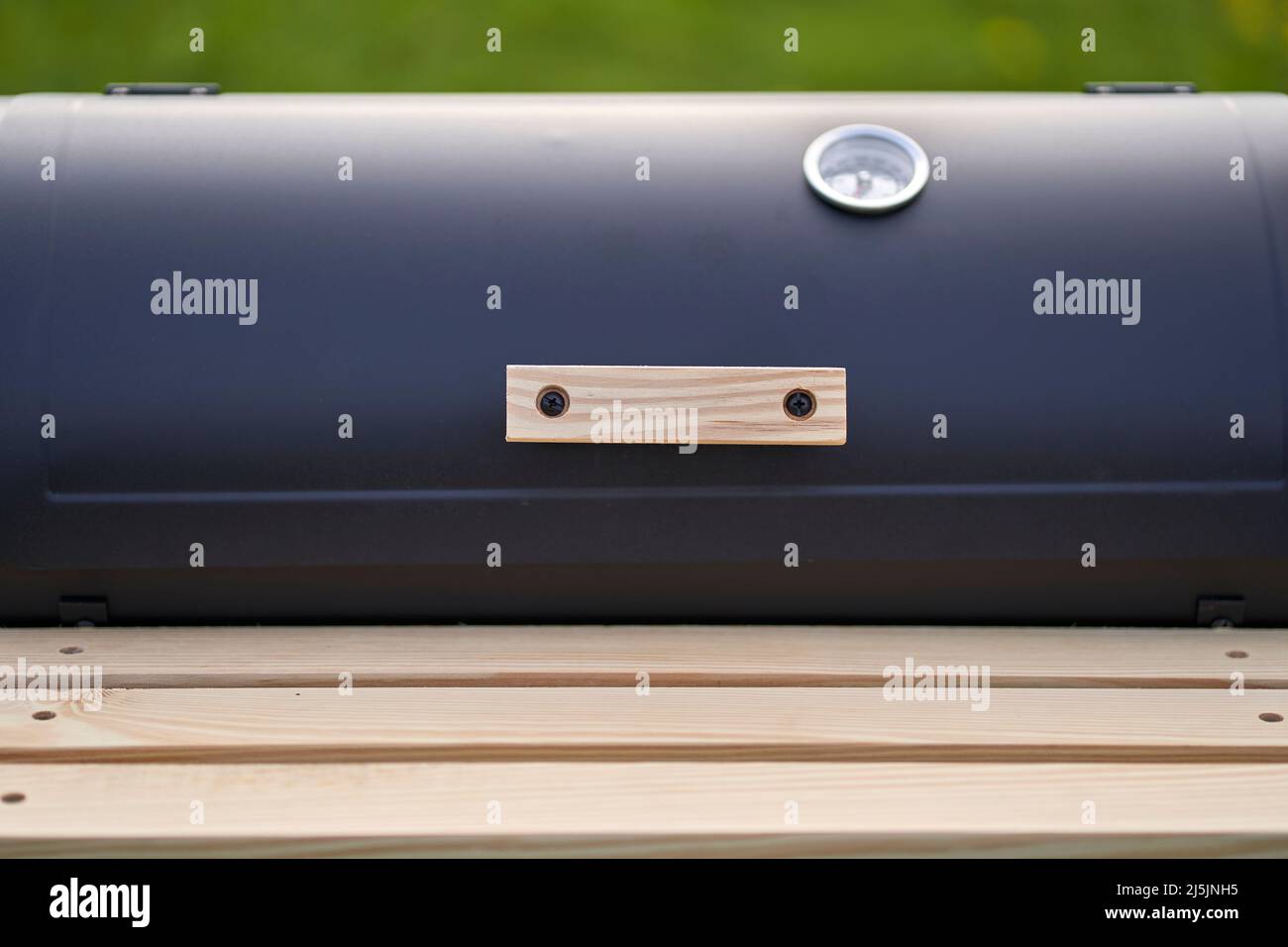 New smoker barbecue grill. Equipment for cooking and smoking. Wooden ...