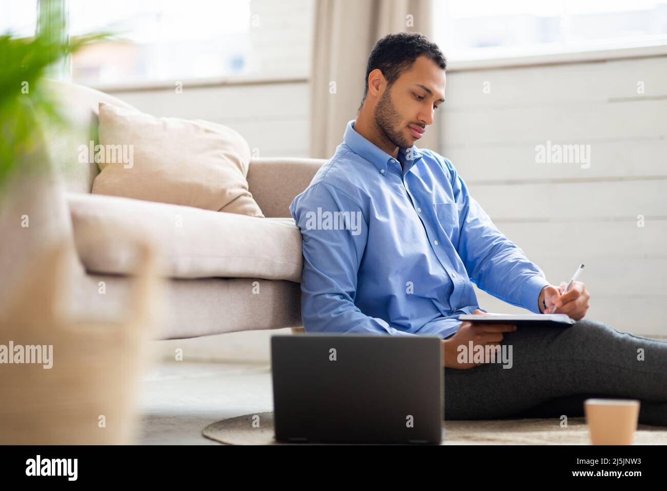 Portrait of young Arab man using laptop and writing Stock Photo - Alamy