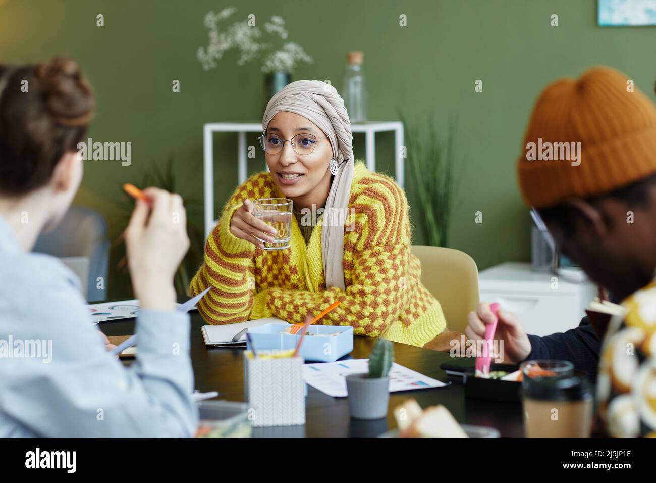 Portrait of creative young woman working with diverse design team at ...