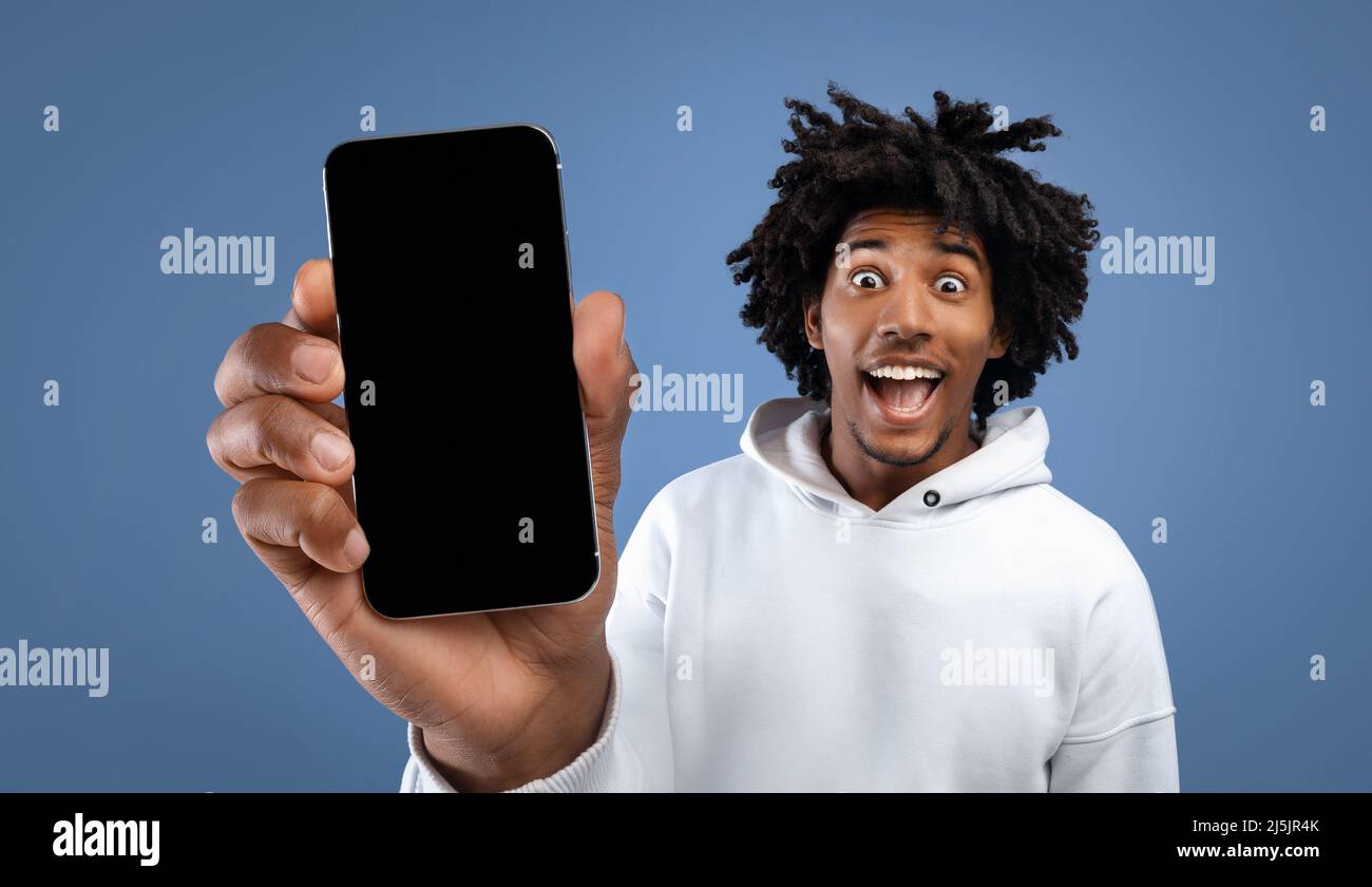 Amazed funky black guy showing cell phone with empty screen Stock Photo ...