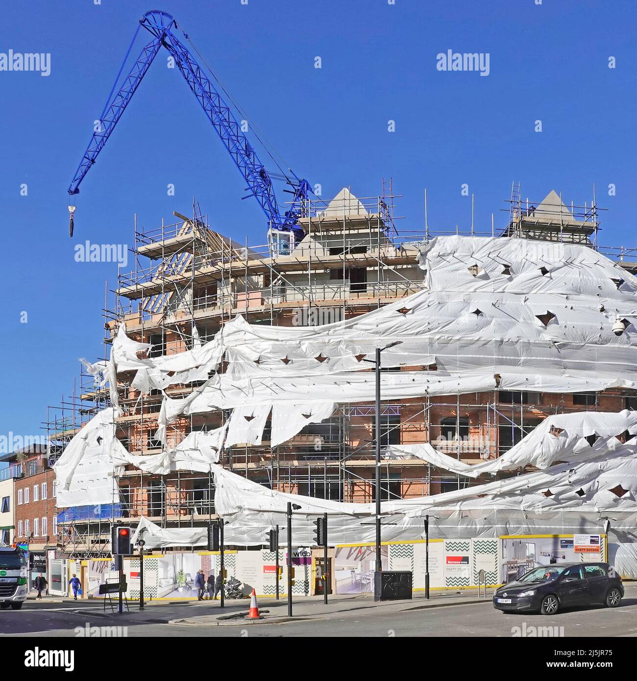 Building construction site crane with plastic safety cocoon on ...