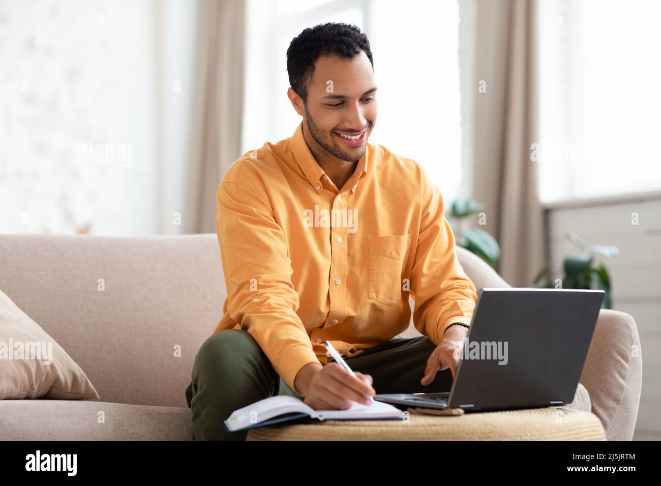Portrait of young Arab man writing in notebook Stock Photo - Alamy