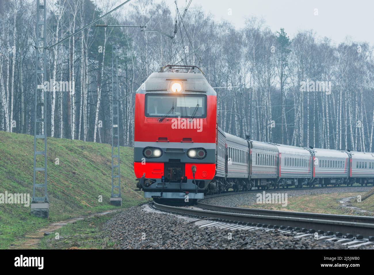 Passenger train moves at spring foggy morning Stock Photo - Alamy