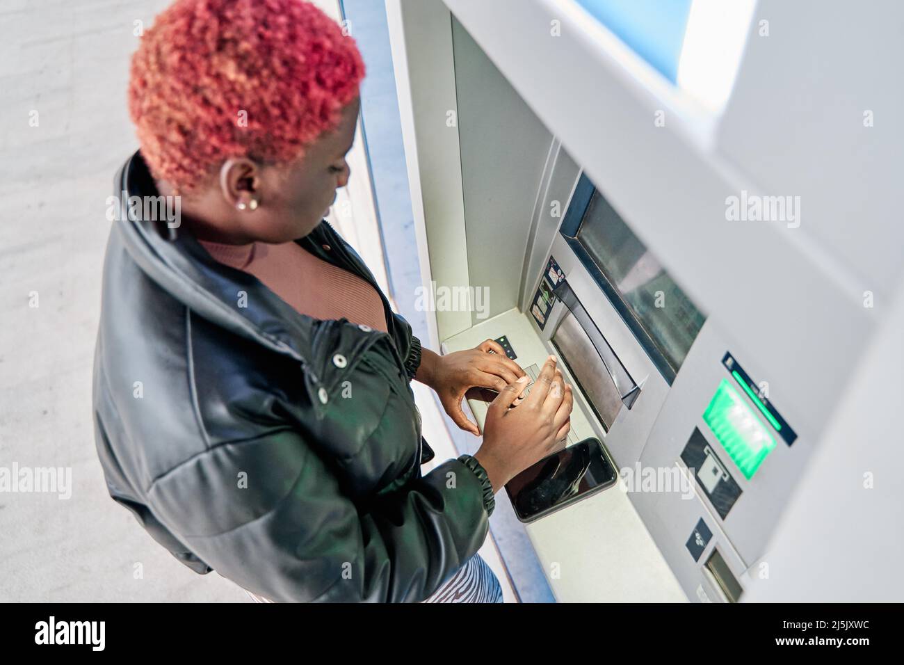 top view of a woman using an ATM to withdraw money Stock Photo - Alamy