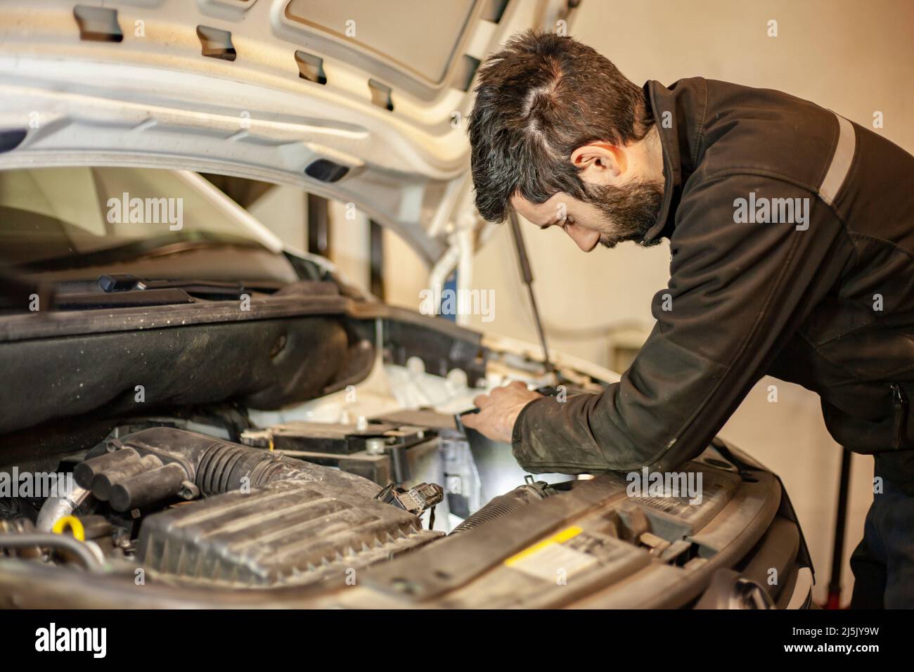 MILAN, ITALY 24 APRIL 2022: Mechanic at work on the hood of the car ...