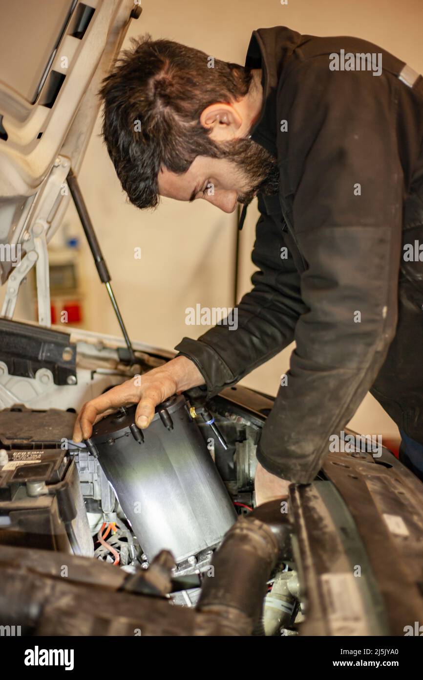 MILAN, ITALY 24 APRIL 2022: Mechanic at work on the hood of the car ...